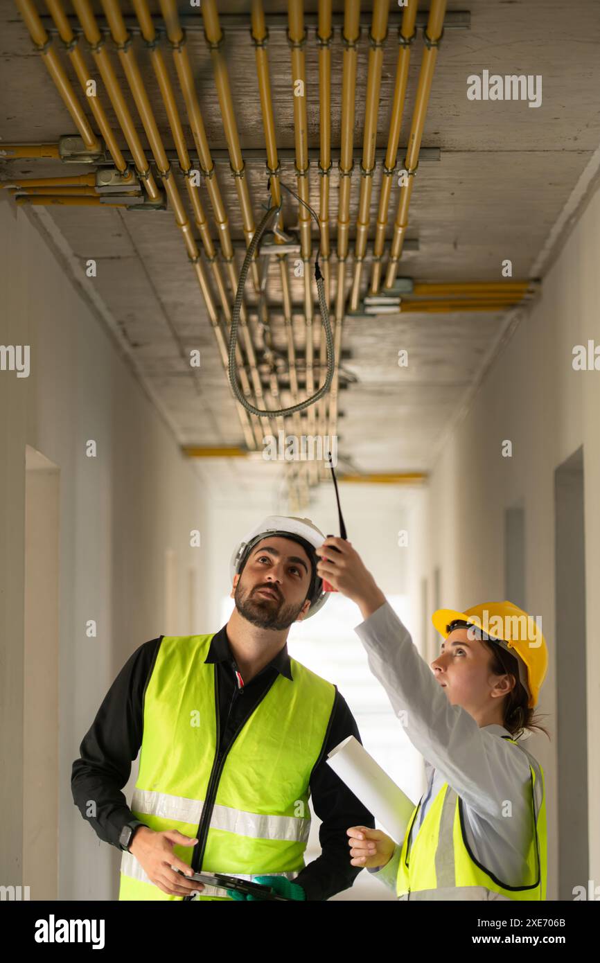 Male and female engineers working on construction site, they are ...