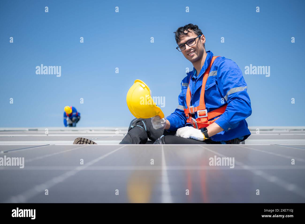 Technician repairing solar panels take off his hat and rest in the ...