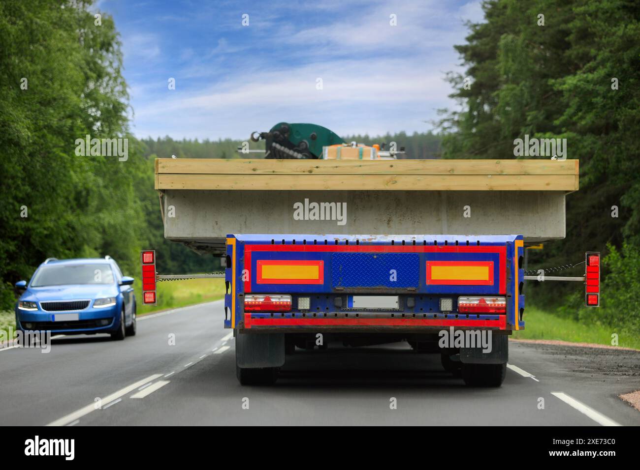Rear view of a heavy truck and trailer transporting oversize load in ...
