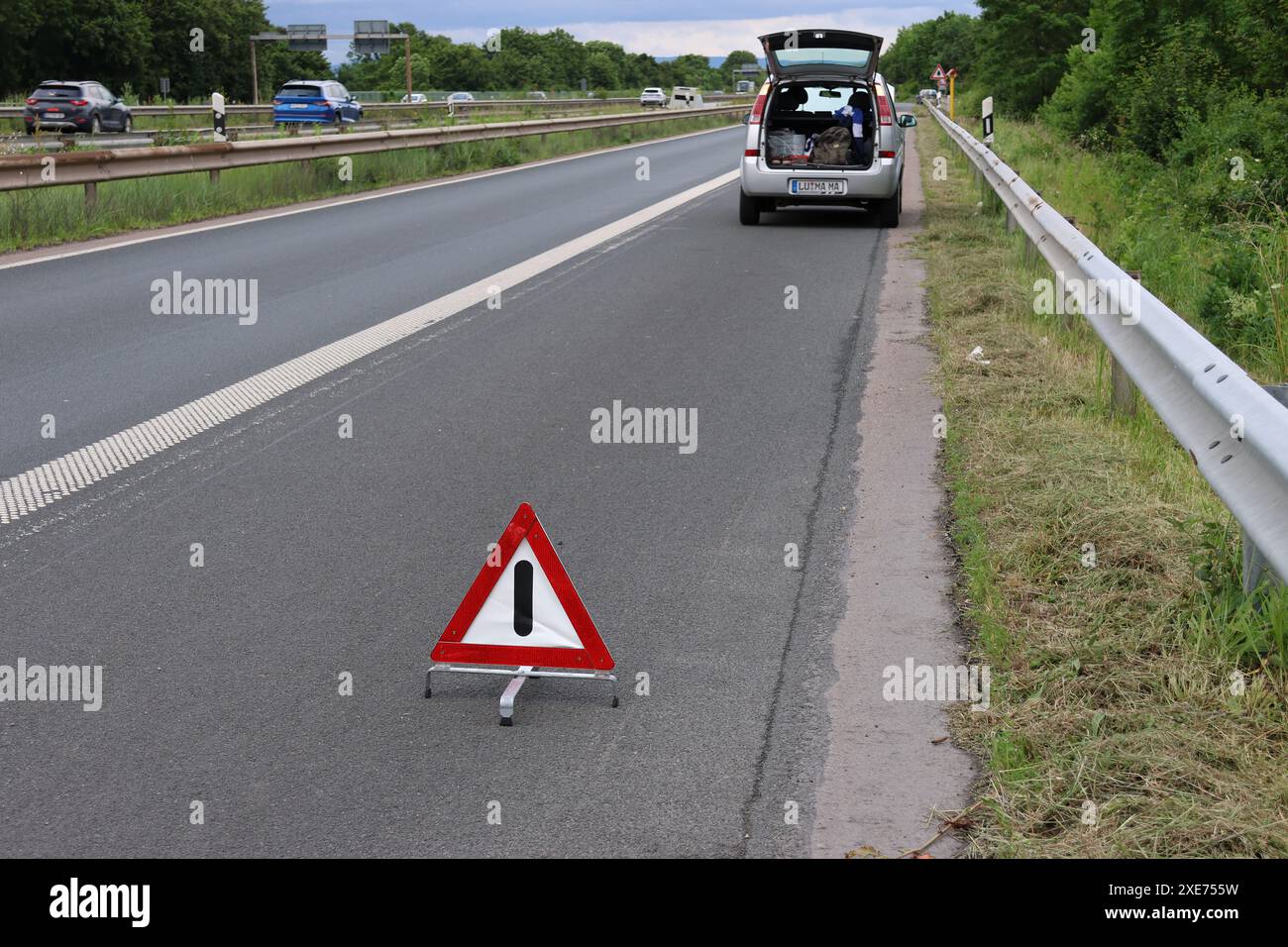 A broken down car stops on the highway with a danger and warning ...