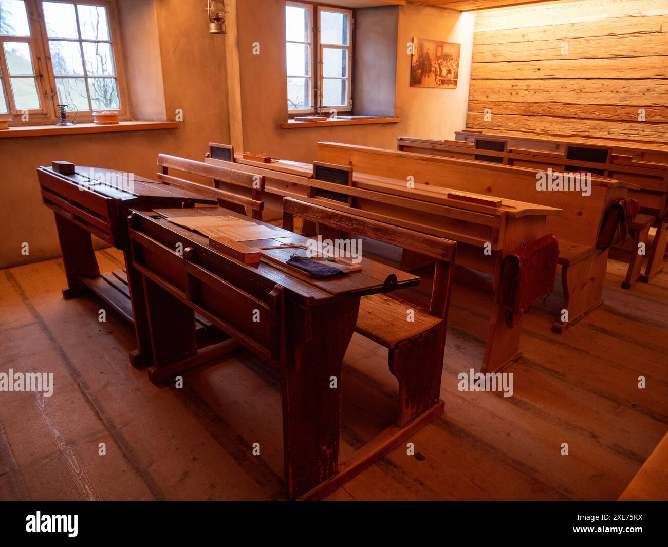 A vintage classroom with wooden desks and benches, evoking a nostalgic ...