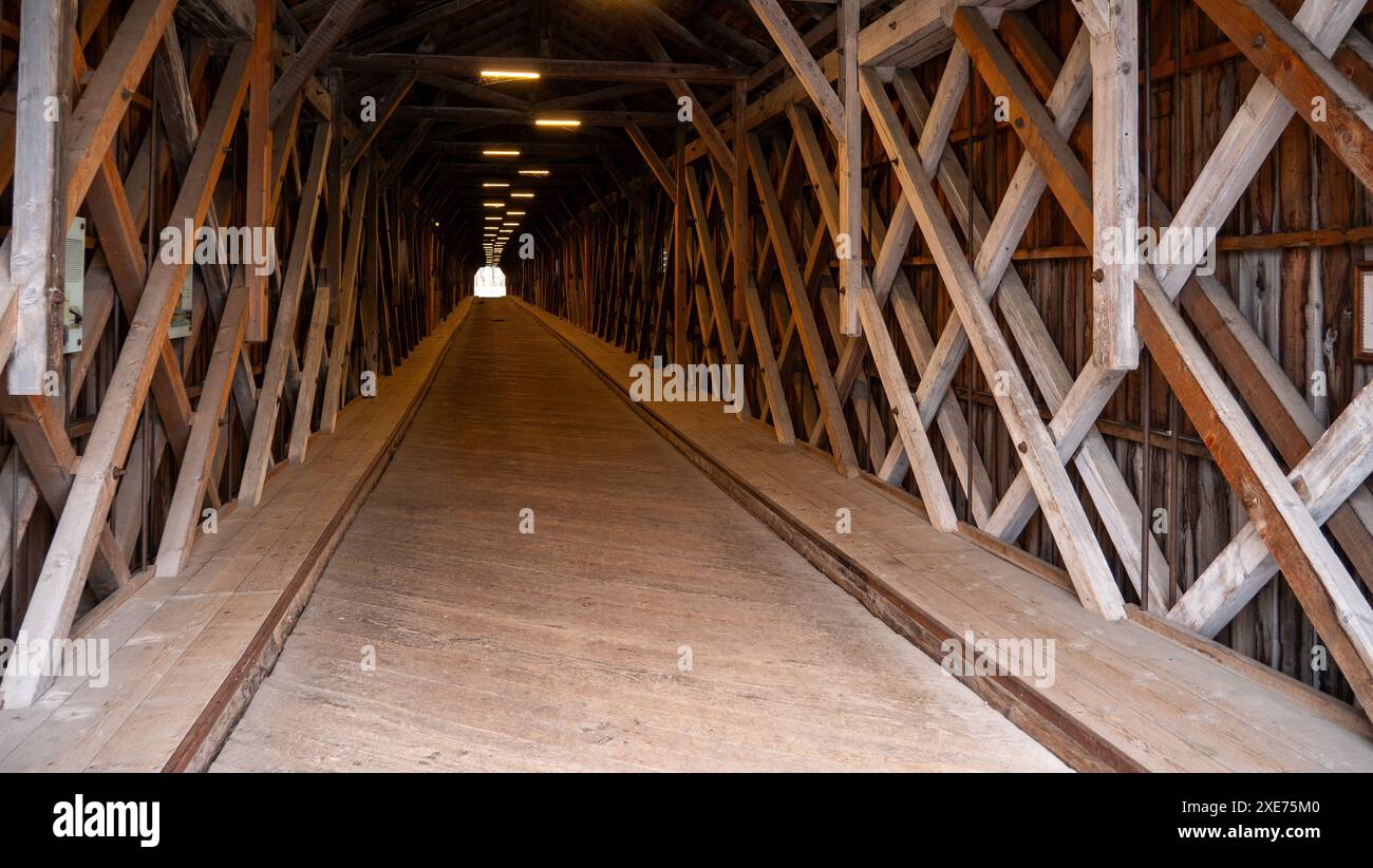 Interior view of a wooden covered bridge with crisscrossing beams and a ...