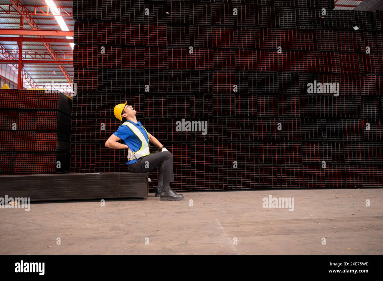 Portrait of a male worker wearing a safety vest and helmet sitting on a ...