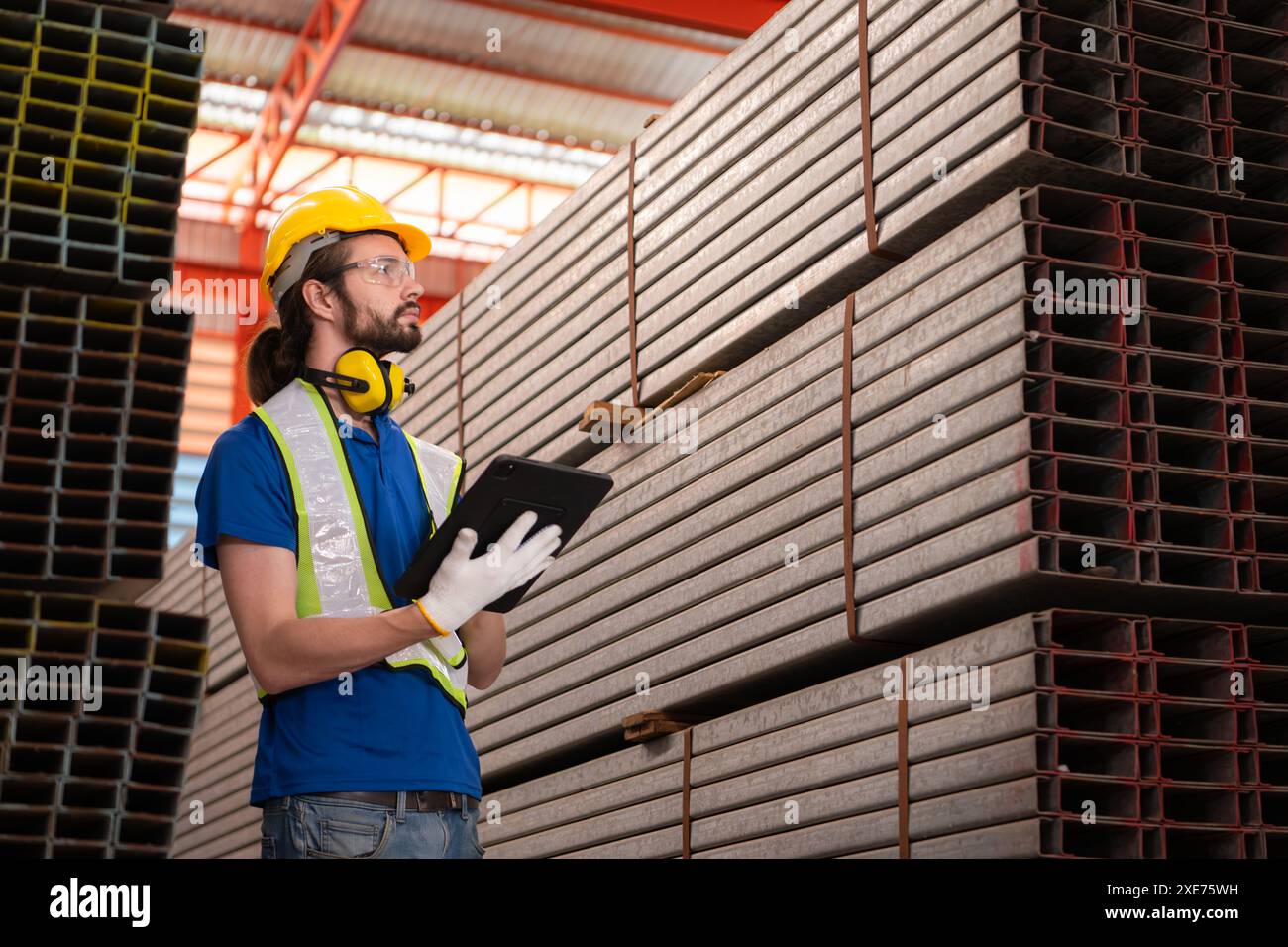 Warehouse worker in hard hats and helmets stand in the warehouse to ...