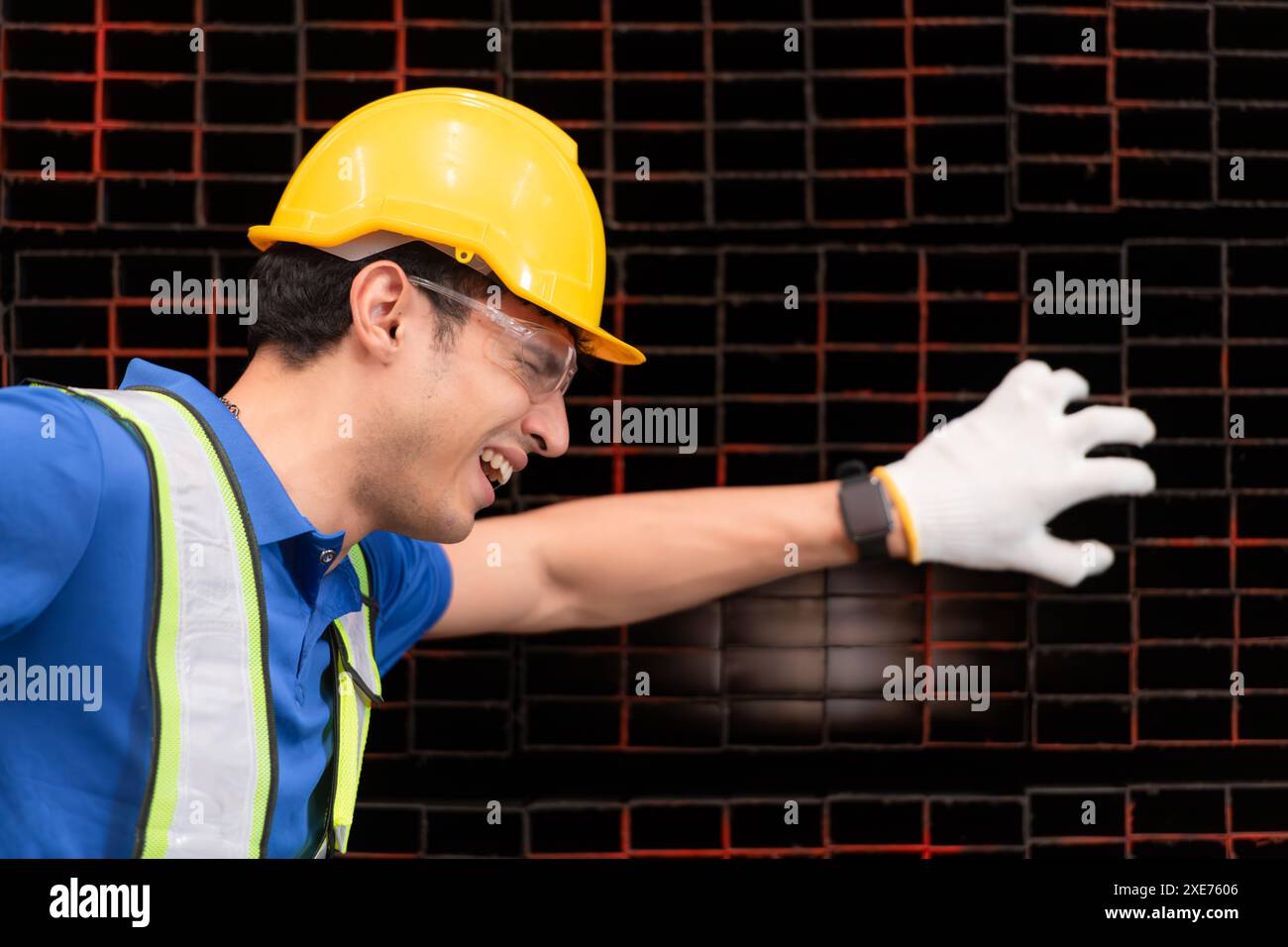 Portrait of a male worker wearing a safety vest and helmet sitting on a ...