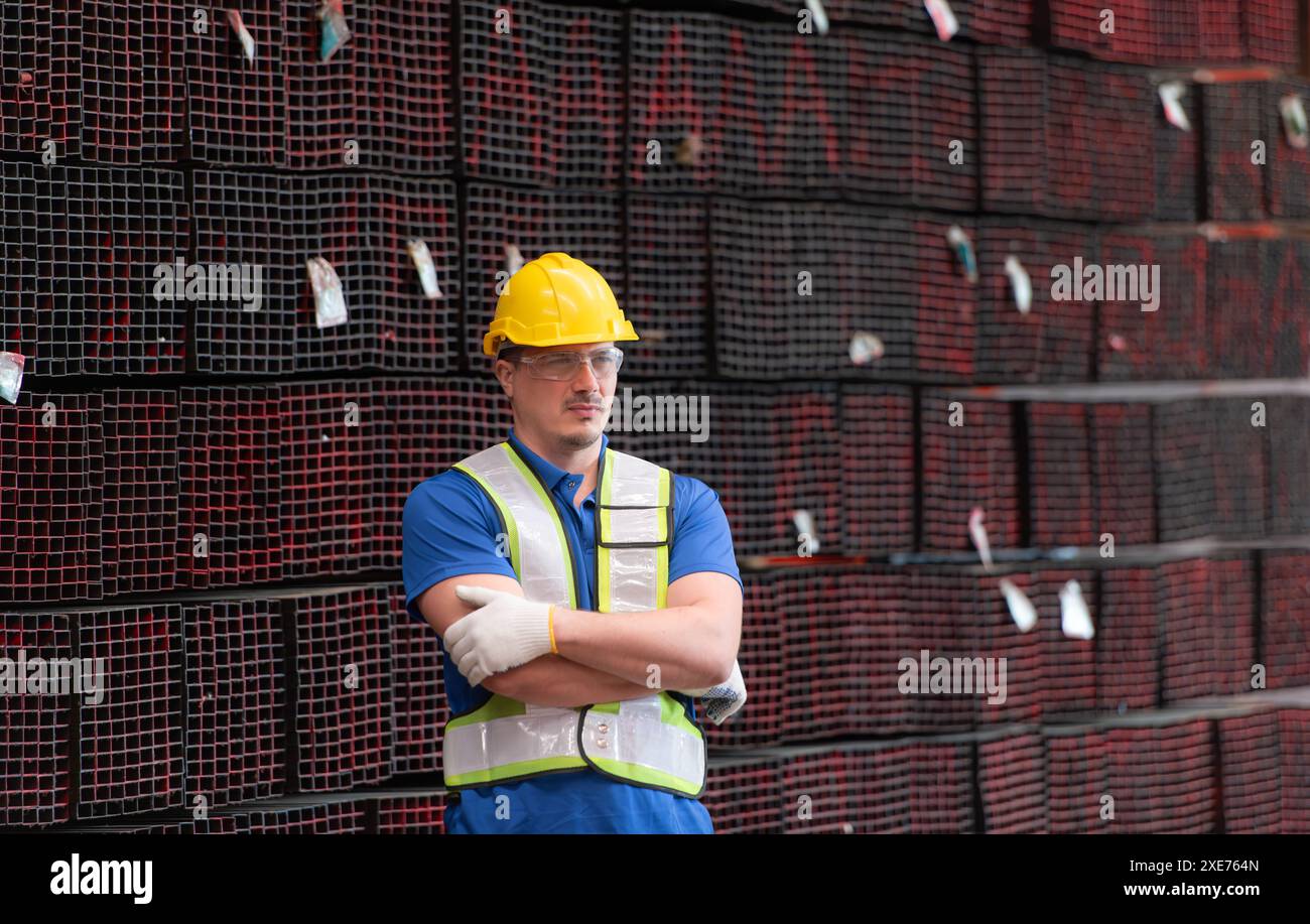 Portrait of a construction worker standing with arms crossed in front ...