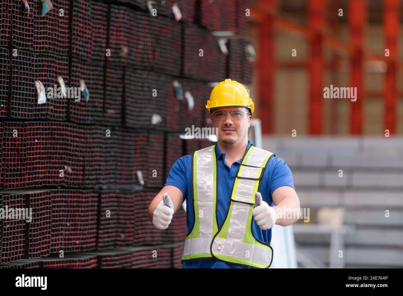 Portrait of a construction worker standing with thumbs up in front of ...