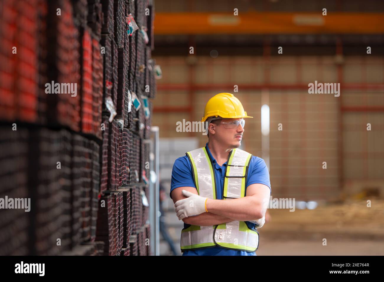 Portrait of a construction worker standing with arms crossed in front ...