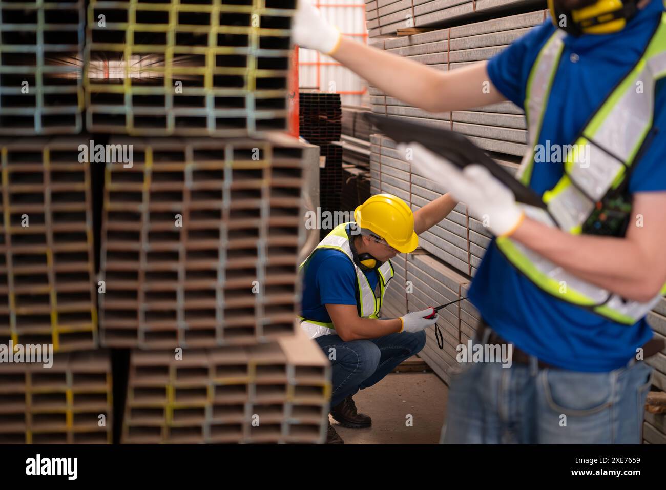 Warehouse worker in hard hats and helmets stand in the warehouse to ...