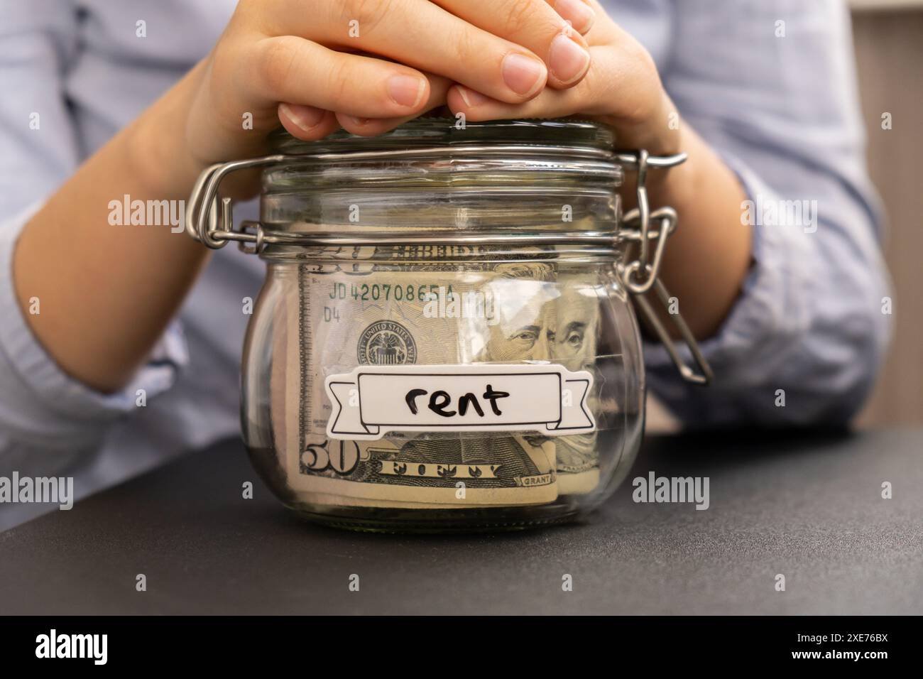 Female hands holding Glass jar full of American currency dollars cash ...