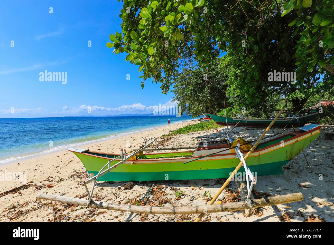 Outrigger canoes on Pulisan beach with Tangkoko mountain and national ...
