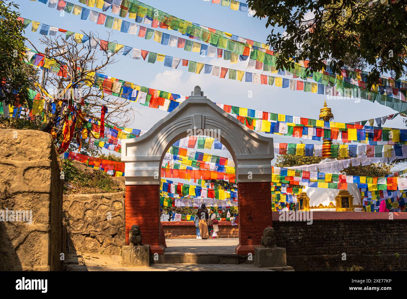 Stone arch gate leading to Kashyap Stupa with colorful Buddhist prayer ...