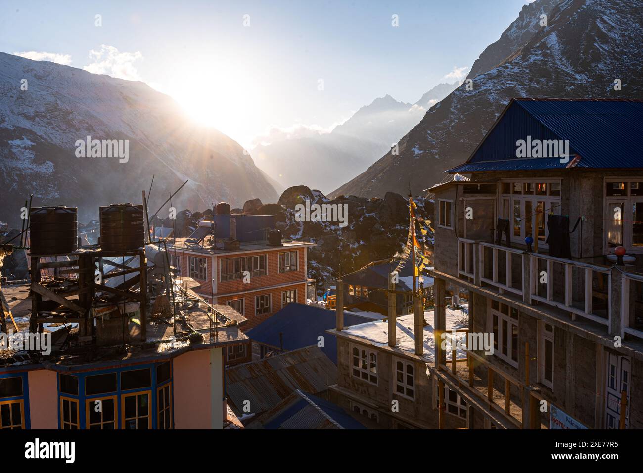 Wide angle view over the rooftops of Kyanjin Gompa with gold light of ...