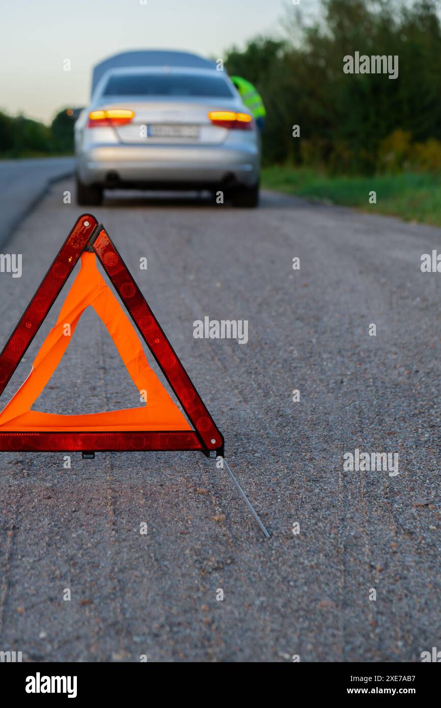 Unrecognizable sad driver in reflective vest. Male driver standing near ...