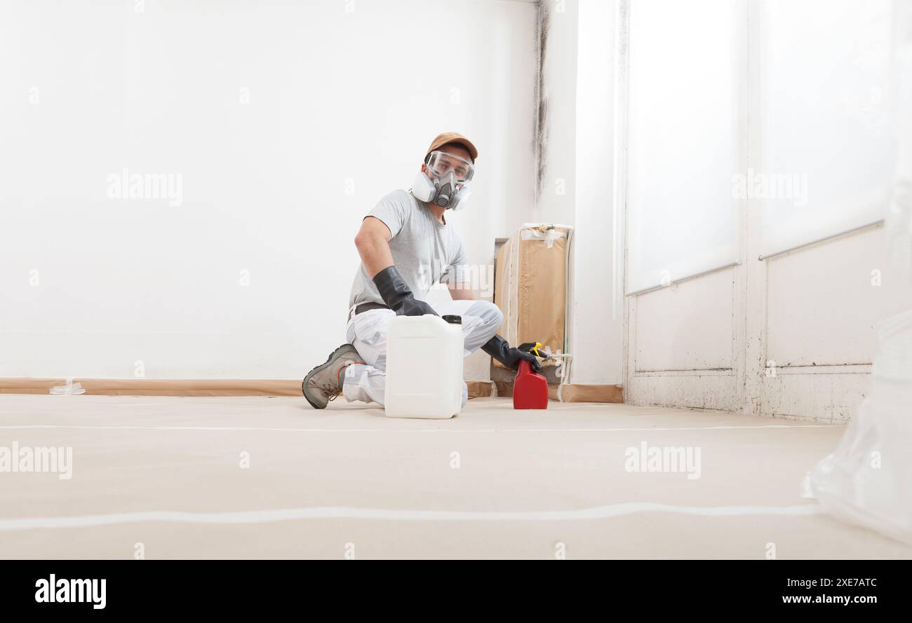 Man Worker Spraying Product on Wall to Remove Mold, Wearing Protective ...