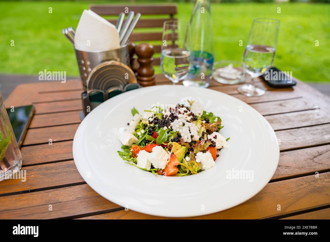 Avocado salad with fresh vegetables, arugula and cheese in a European ...