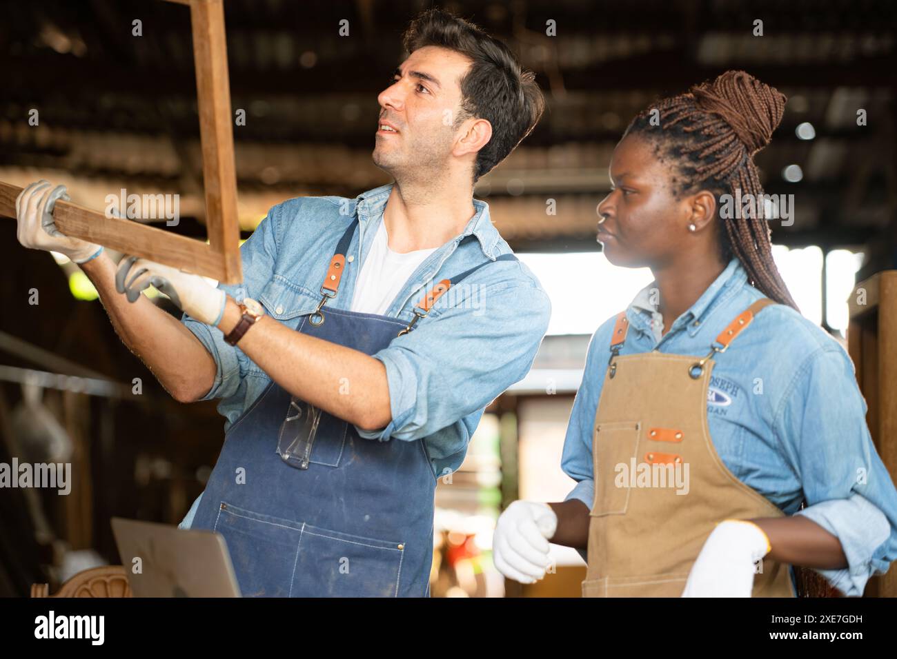 Carpenter and his assistant working together in a carpentry workshop ...