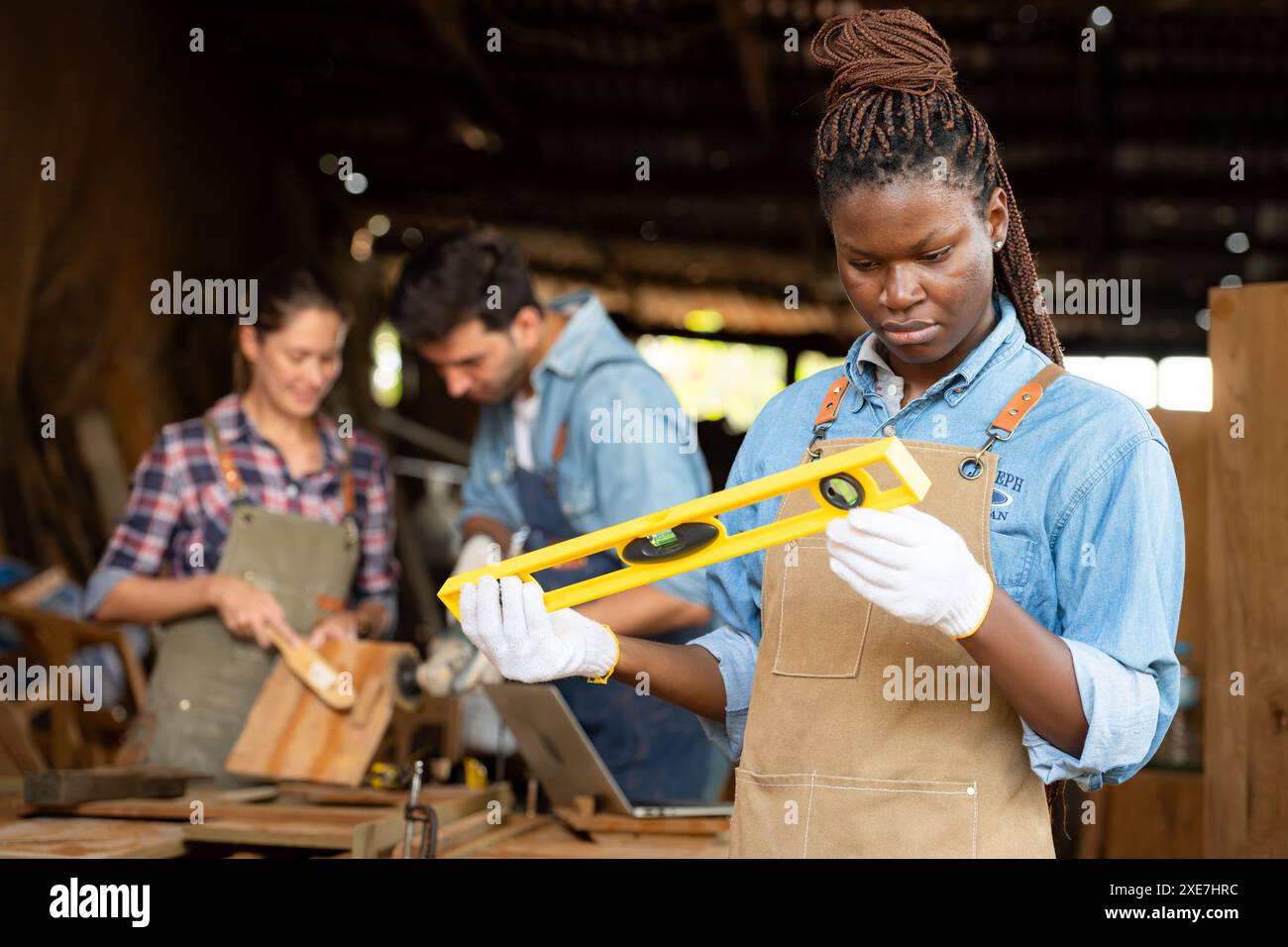Portrait of carpenter female worker standing in front of colleague in ...