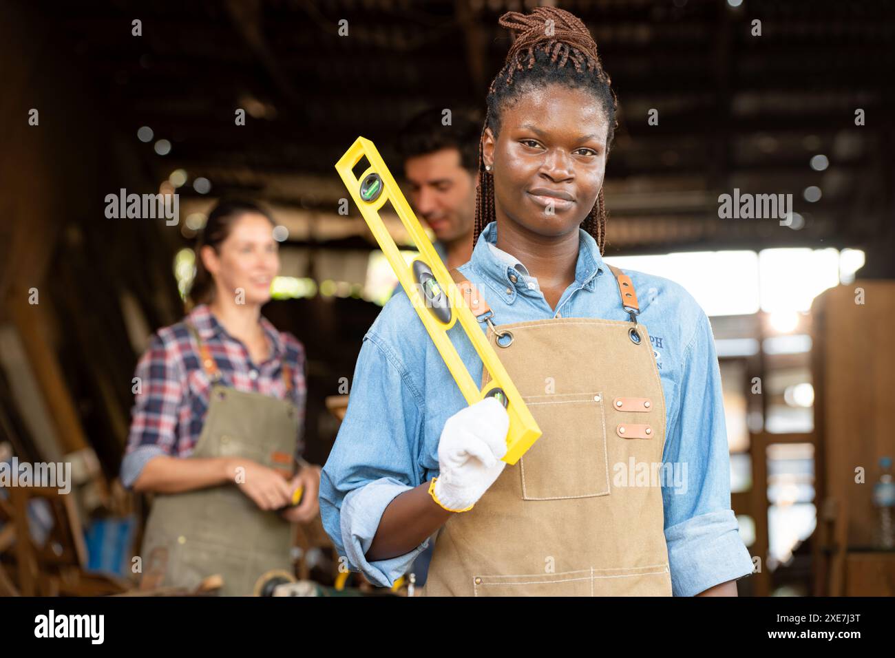 Portrait of carpenter female worker standing in front of colleague in ...