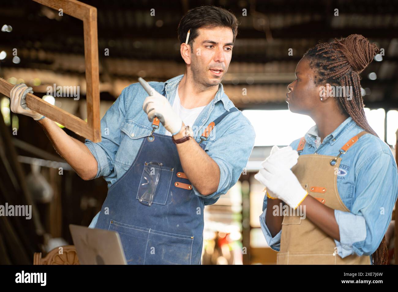 Carpenter and his assistant working together in a carpentry workshop ...
