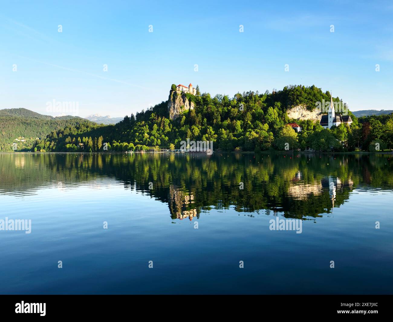 Bled Castle and the Church of St Martin reflected in Lake Bled on a ...