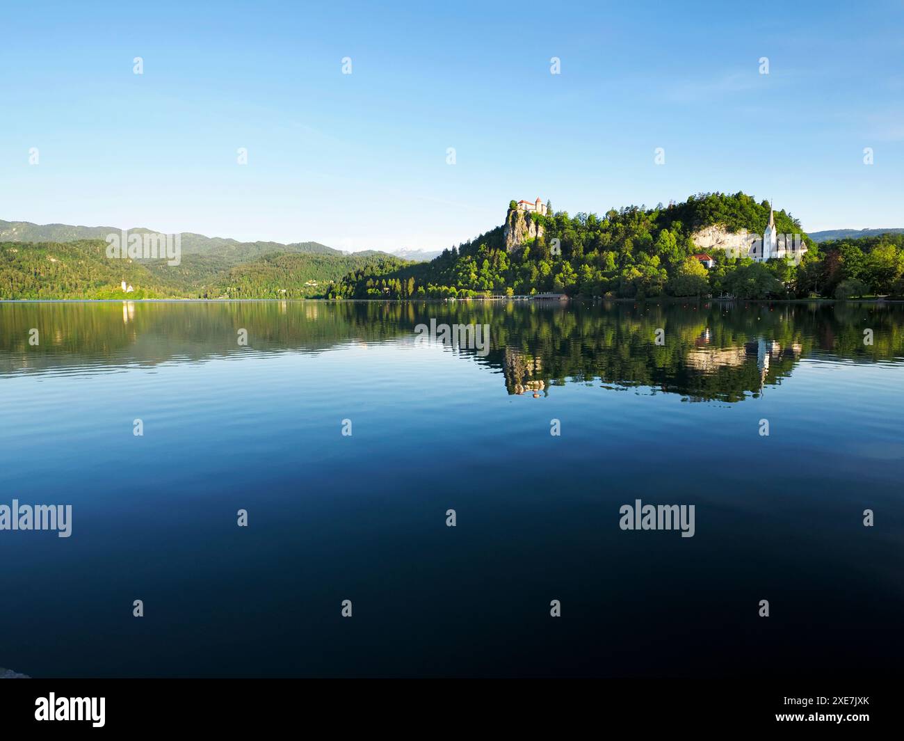 Bled Castle and the Church of St Martin reflected in Lake Bled on a ...