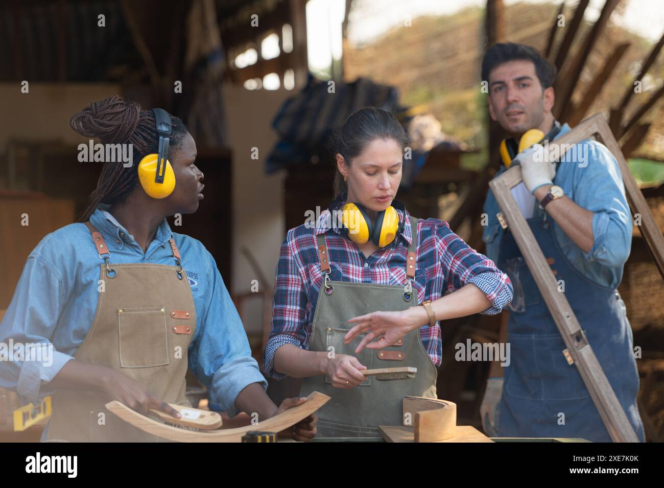 Carpenter and his assistant working together in a carpentry workshop ...