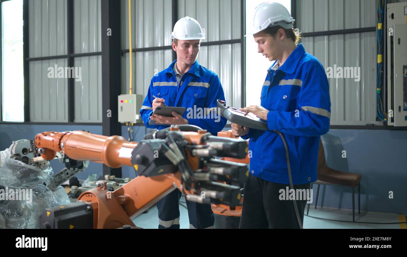 Engineer and technician working with robot arm in factory. Industry and ...
