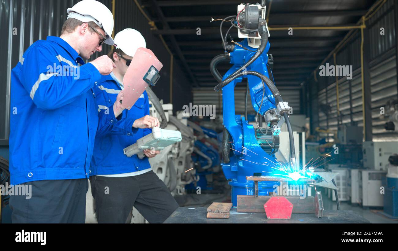Industrial workers working with robotic arm welding machine in factory, Robotic arm welding ...