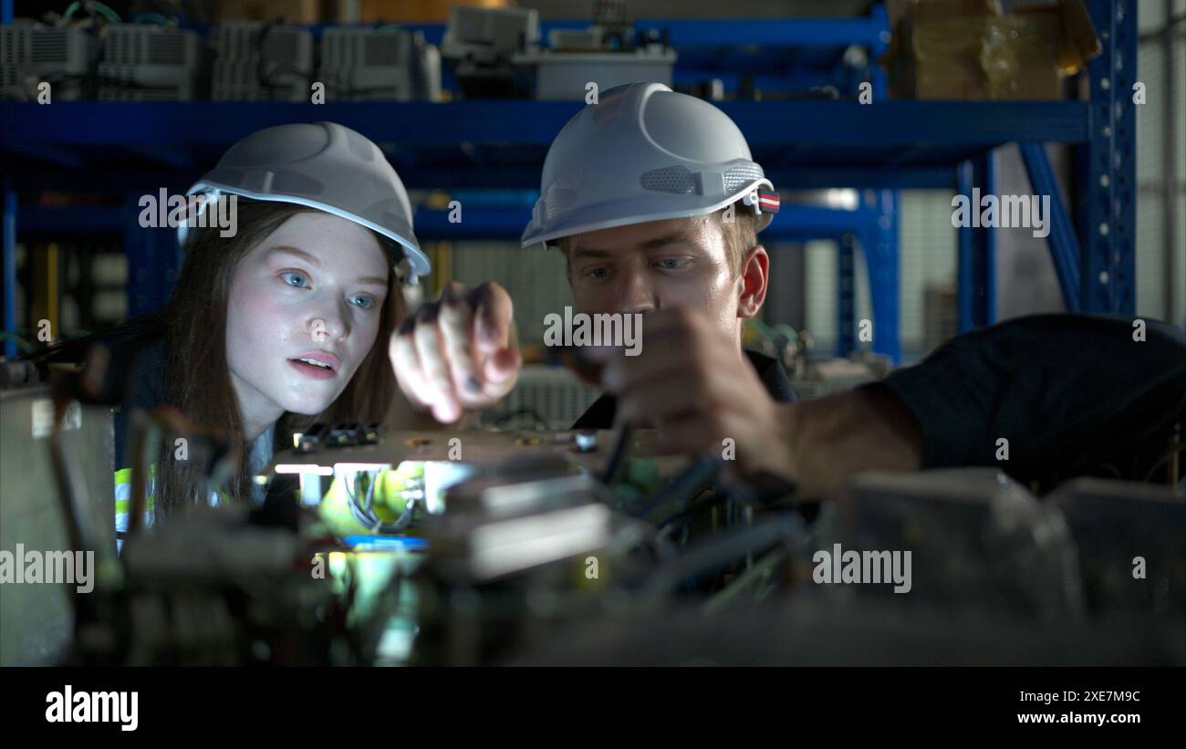 A young female engineer and a male supervisor work together in robotic ...