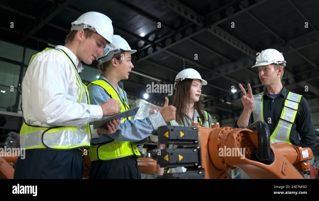 Group Of Engineers And Technicians Working Together In A Robotic Arm Factory Inspecting Robot