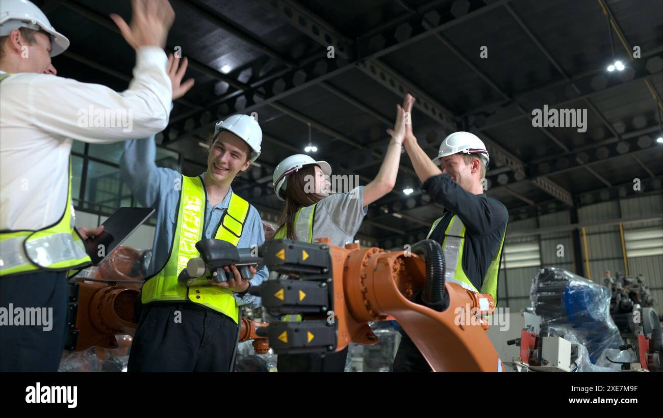 Group of engineers and technicians working together in a robotic arm ...