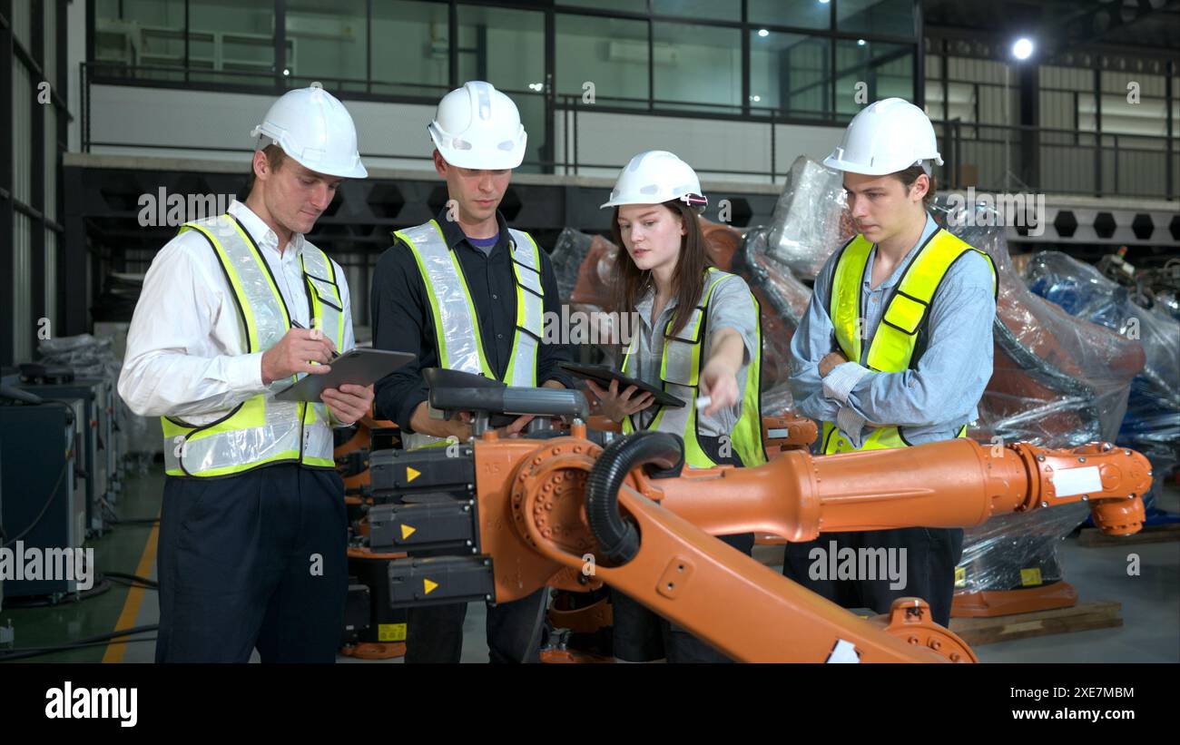 Group Of Engineers And Technicians Working Together In A Robotic Arm Factory Inspecting Robot