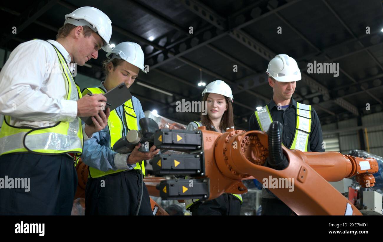 Group Of Engineers And Technicians Working Together In A Robotic Arm Factory Inspecting Robot