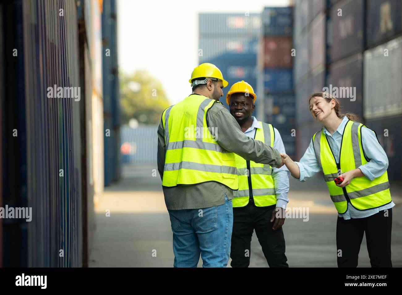 Group of workers in a container storage yard greeting each other during ...
