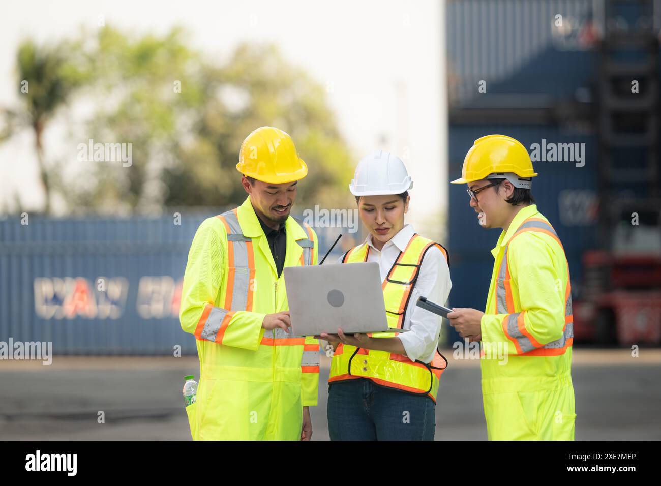 Group of engineers working with laptop in the container yard. This is a freight transportation ...