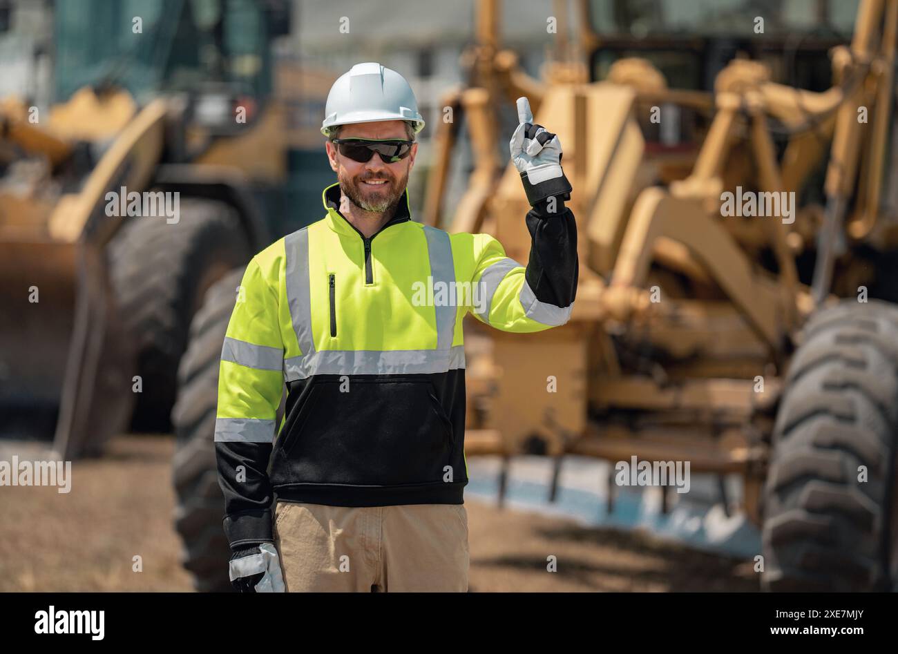 Builder in helmet with excavator for construction at the construction ...