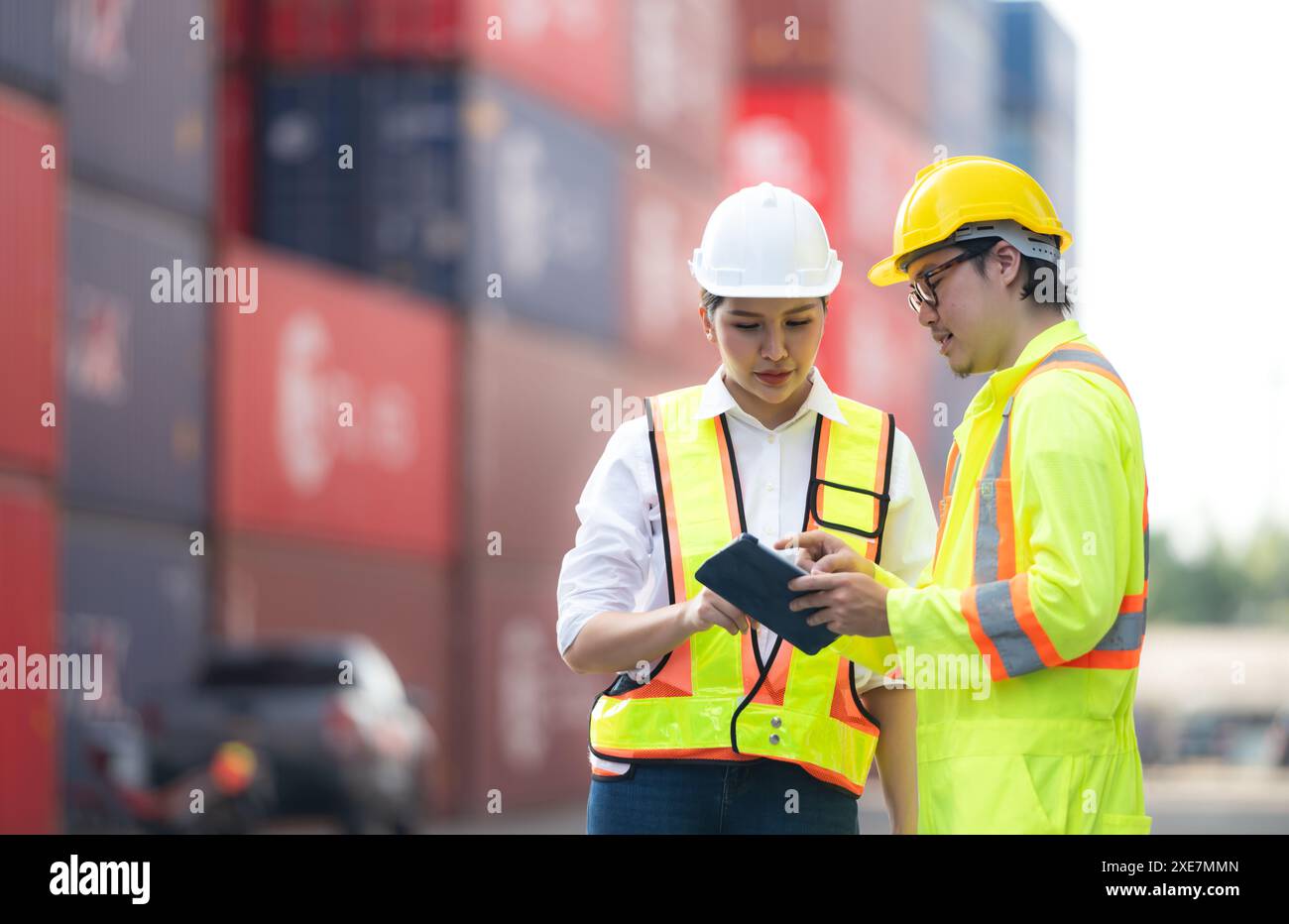 Portrait of Asian woman engineer and worker working with co-worker at overseas shipping ...