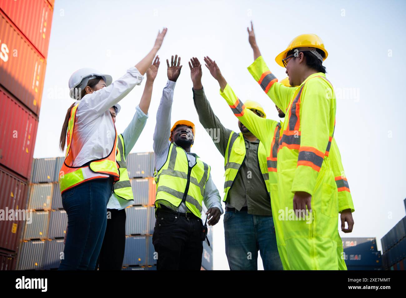 A group of happy team workers stood hand in hand to show their strength ...