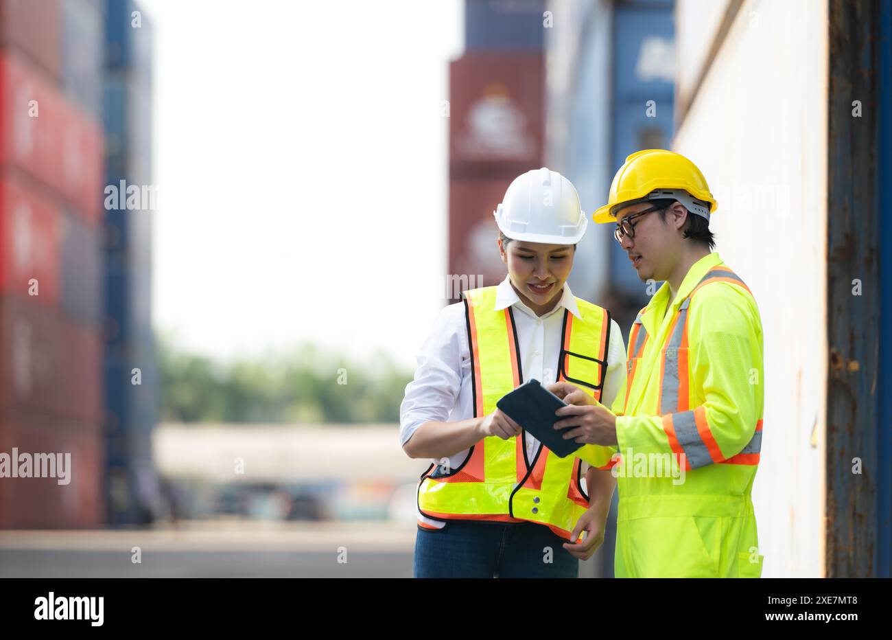 Portrait of Asian woman engineer and worker working with co-worker at overseas shipping ...