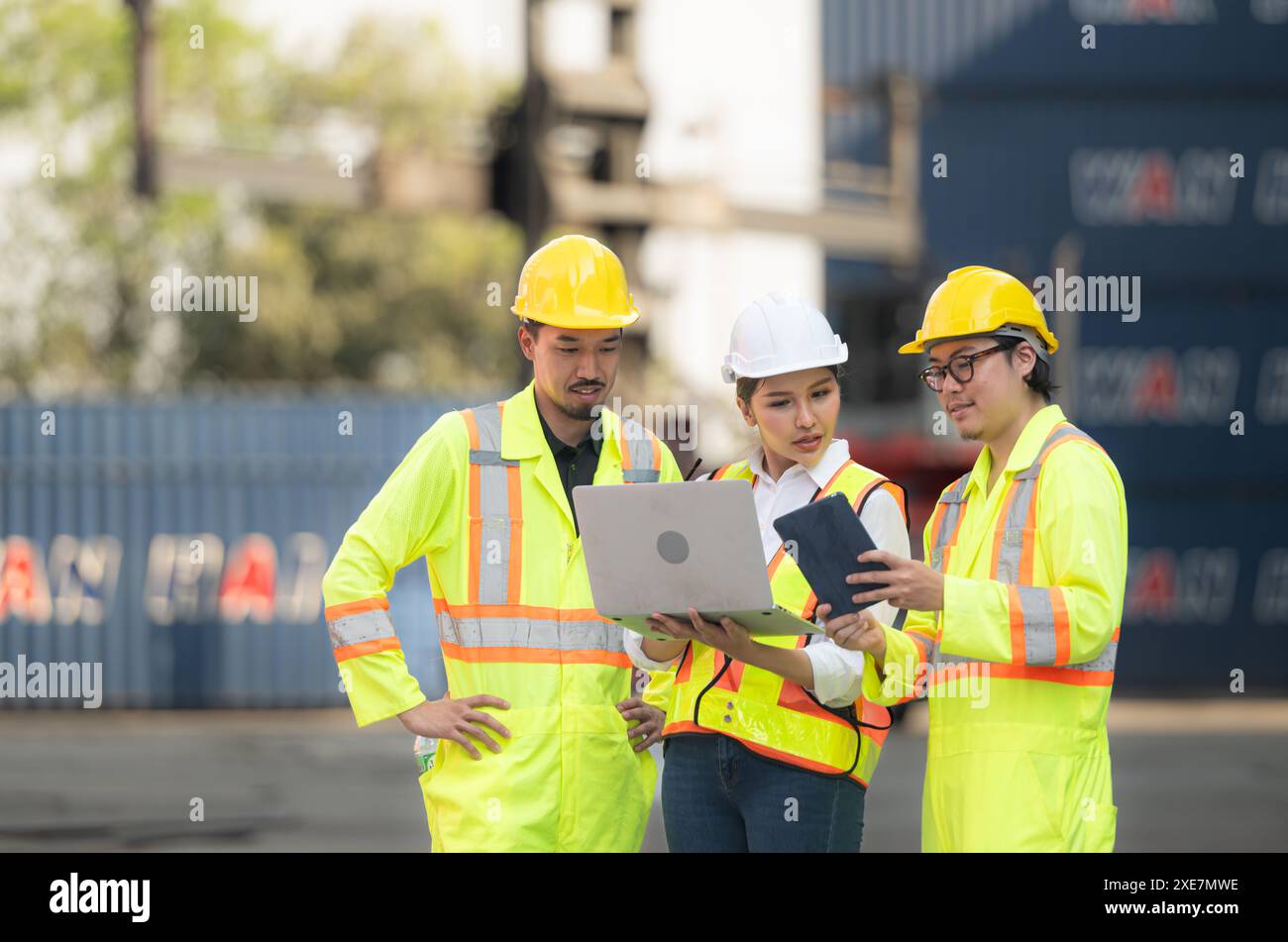 Group of engineers working with laptop in the container yard. This is a ...