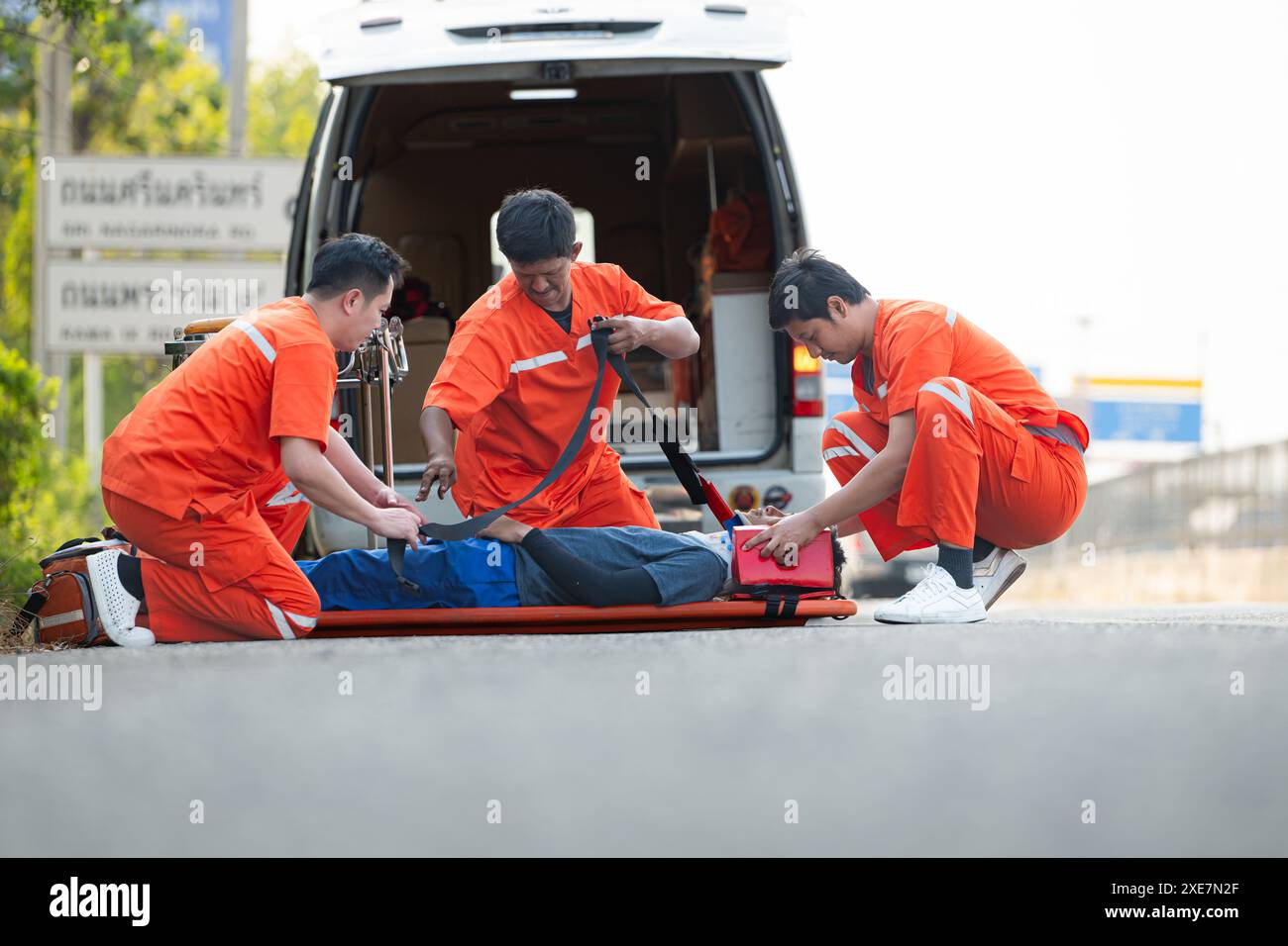 The paramedic is assisting an injured man in an emergency situation on the road Stock Photo - Alamy