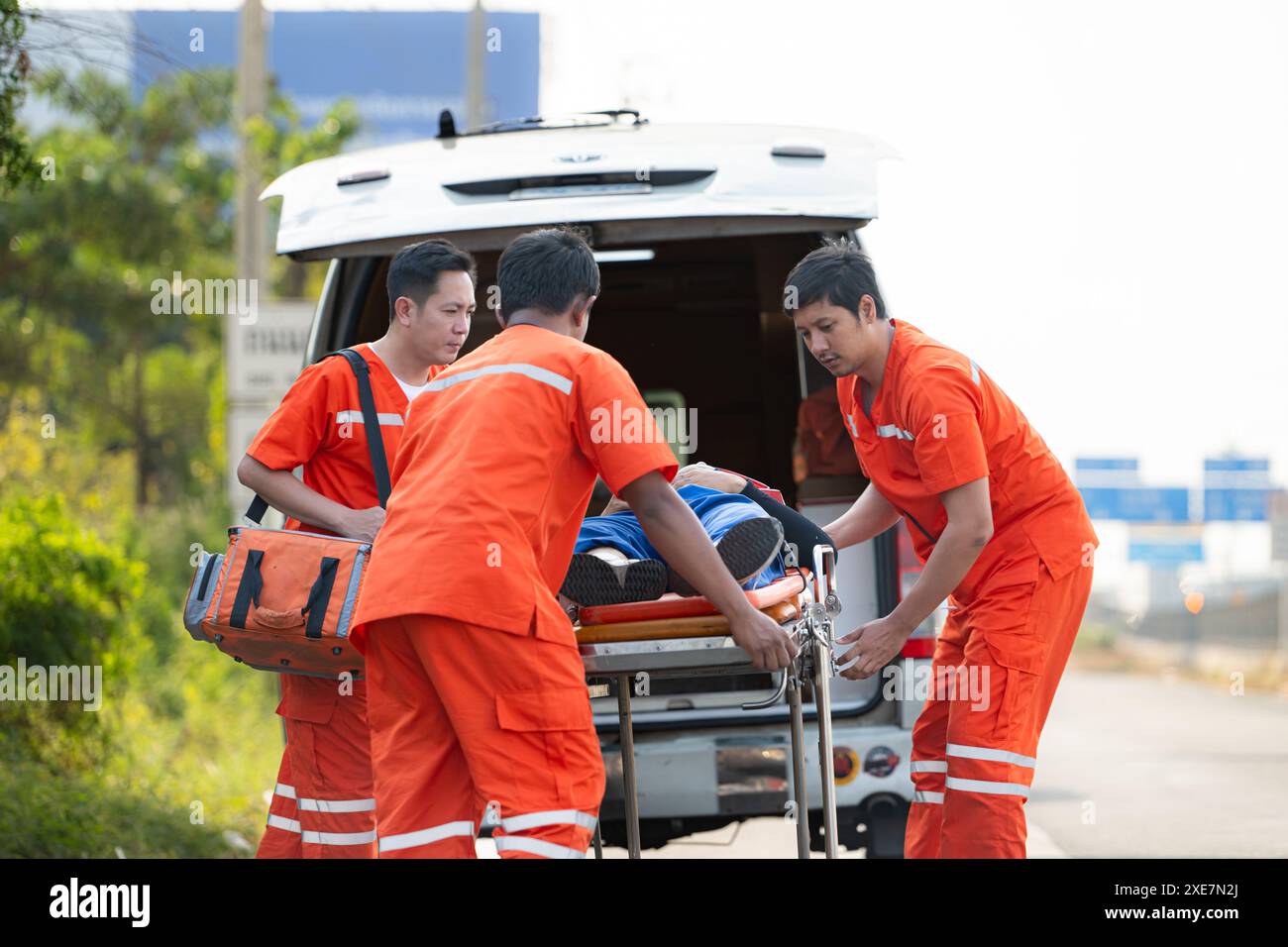 The paramedic is assisting an injured man in an emergency situation on the road Stock Photo - Alamy