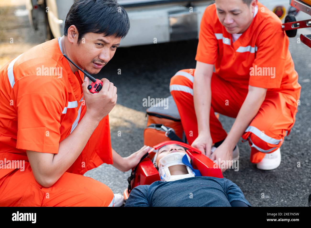 The paramedic is assisting an injured man in an emergency situation on ...