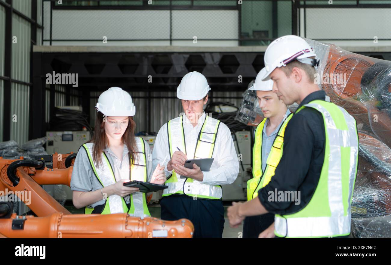 Group Of Engineers And Technicians Working Together In A Robotic Arm Factory Inspecting Robot