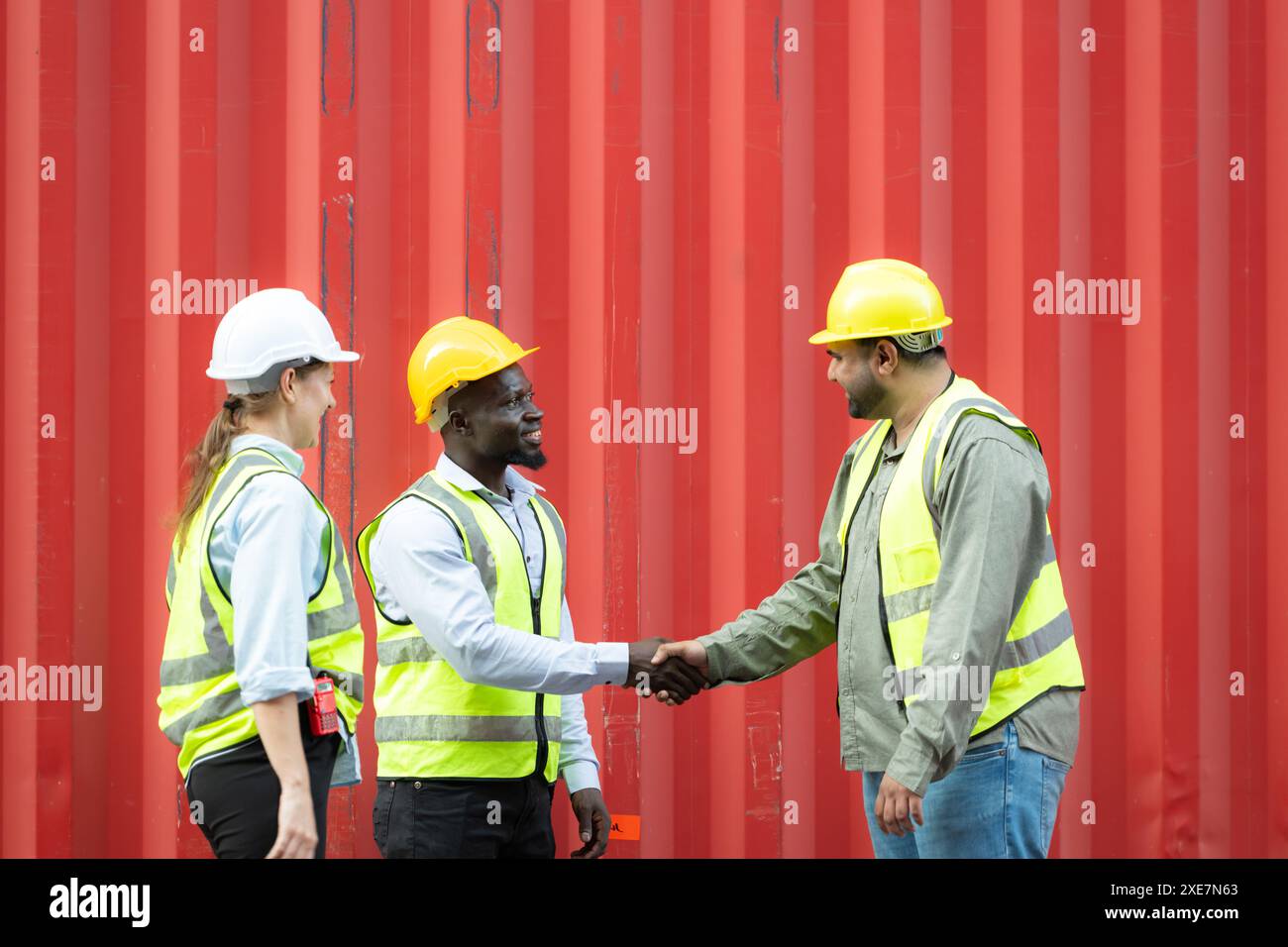 Group of workers in a container storage yard greeting each other during ...