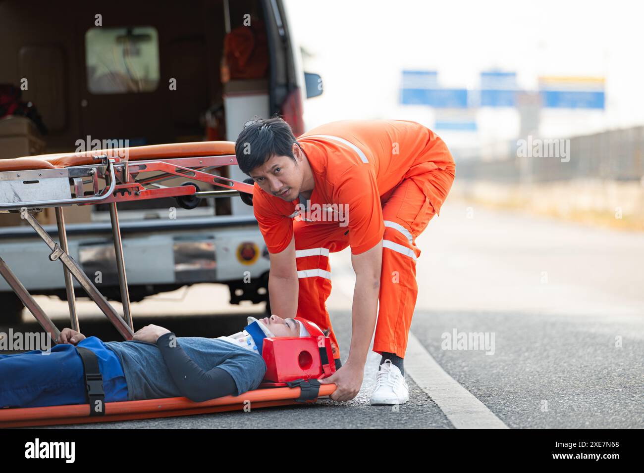The paramedic is assisting an injured man in an emergency situation on ...