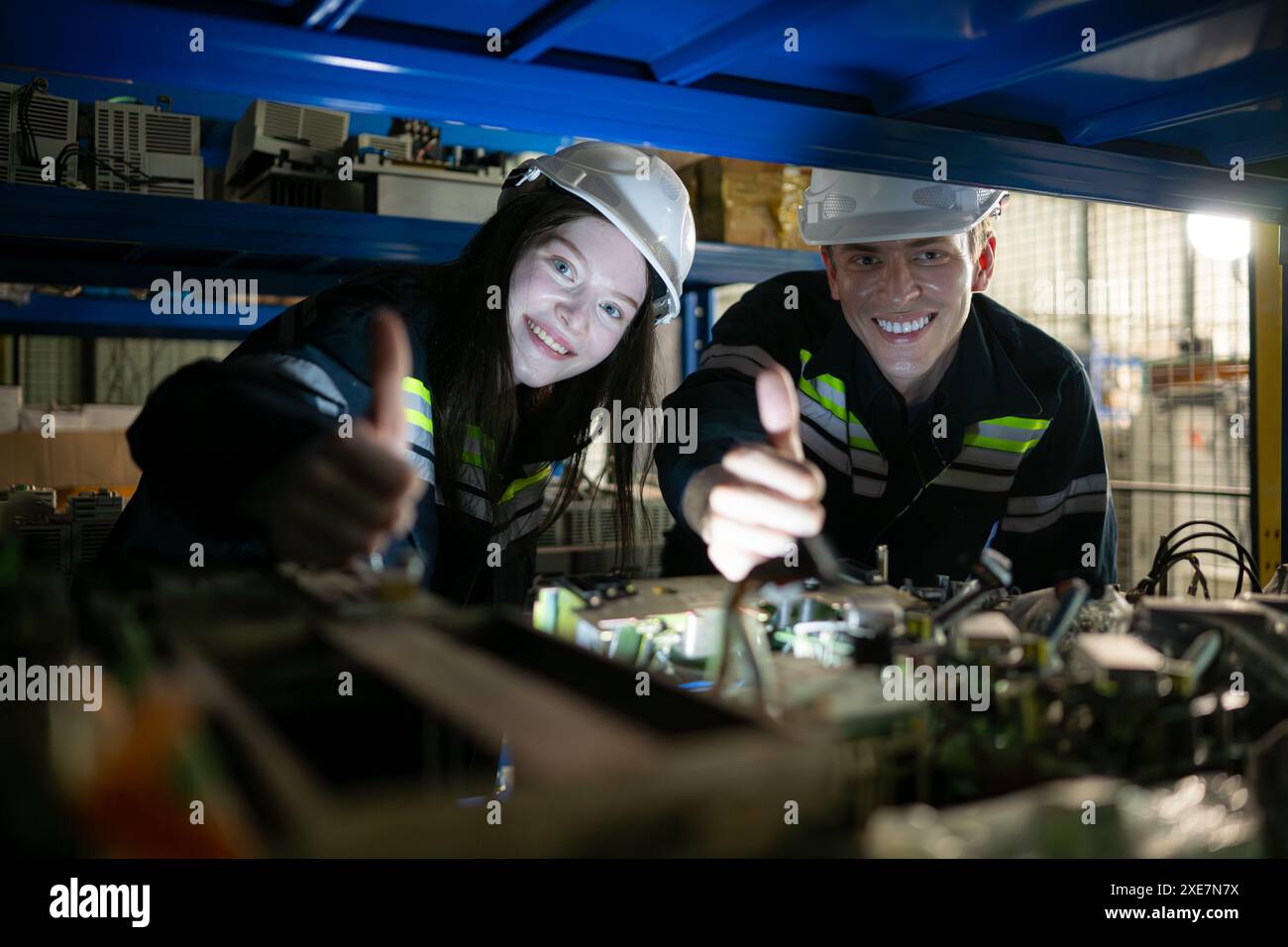 A young female engineer and a male supervisor work together in robotic ...