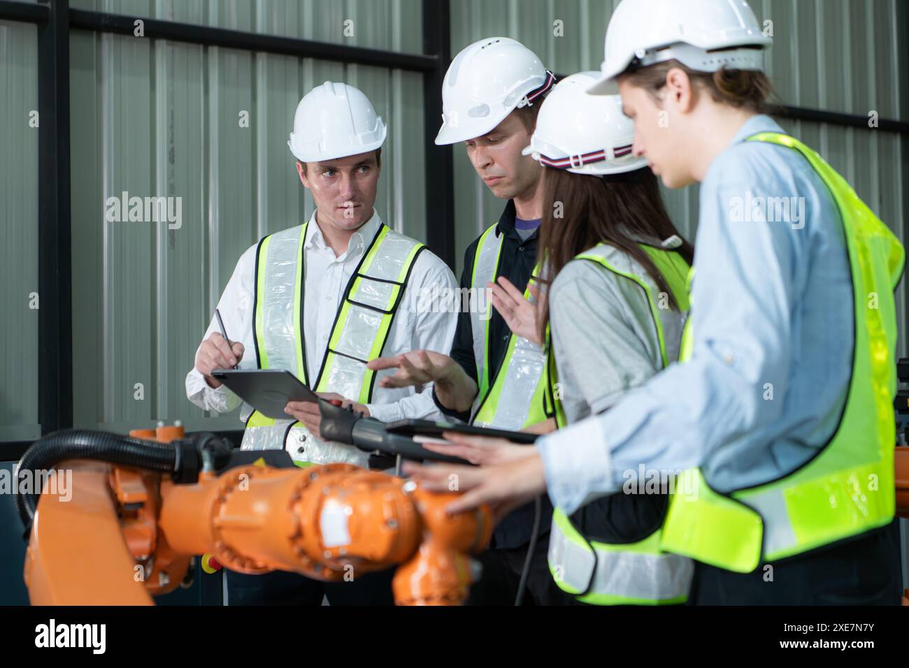 Group of engineers and technicians working together in a robotic arm ...