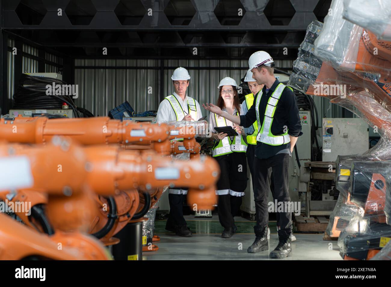 Group Of Engineers And Technicians Working Together In A Robotic Arm Factory Inspecting Robot